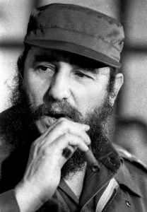 Then Cuban President Fidel Castro smokes a cigar during a meeting of ...